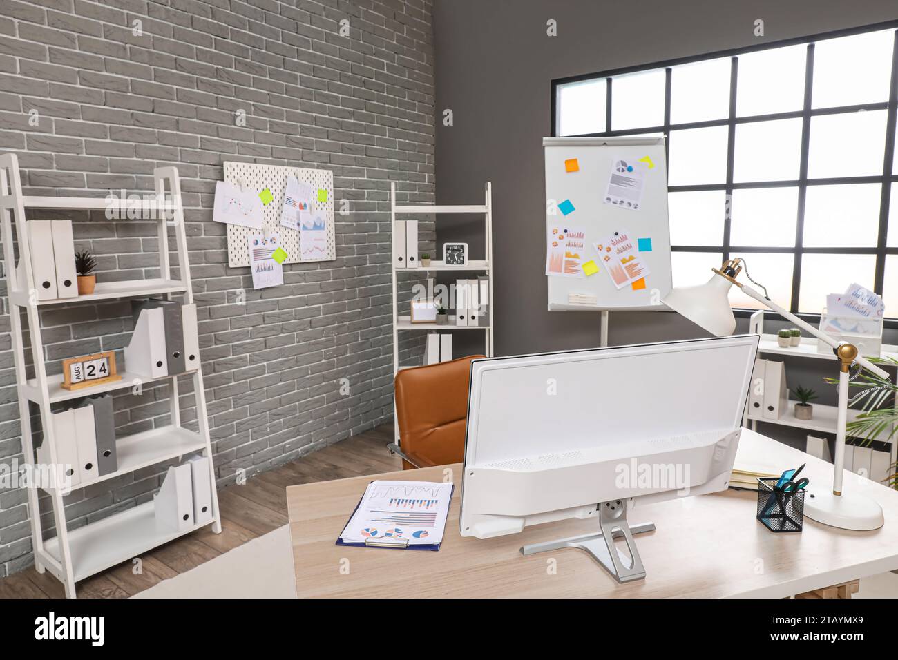 Interior of modern office with workplace, pegboard and shelf units ...