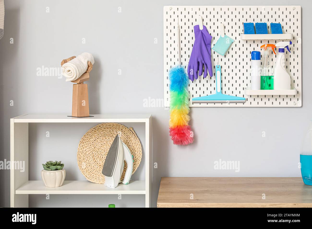 Pegboard with cleaning supplies on light wall in laundry room Stock ...