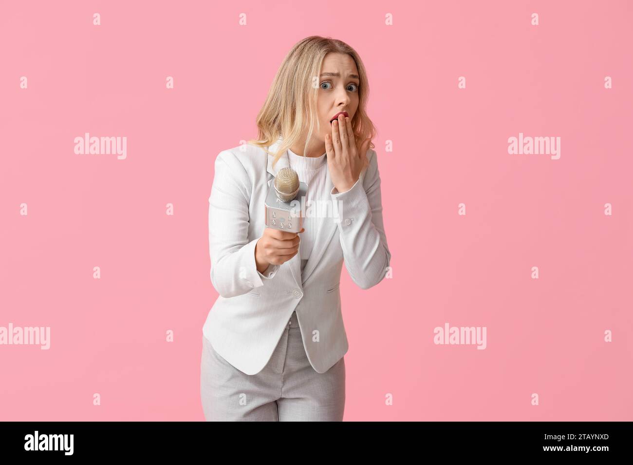 Portrait of shocked female journalist with microphone taking interview ...
