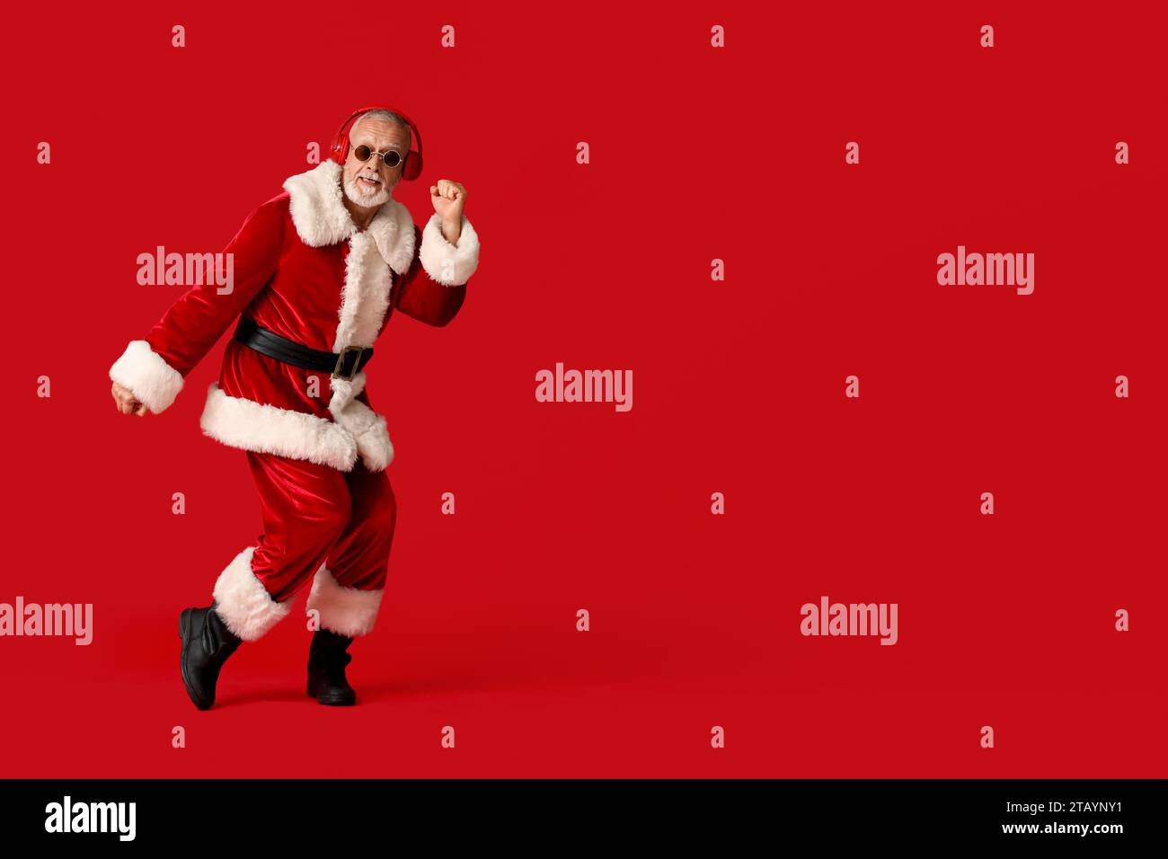 Santa Claus in headphones listening music on red background Stock Photo ...