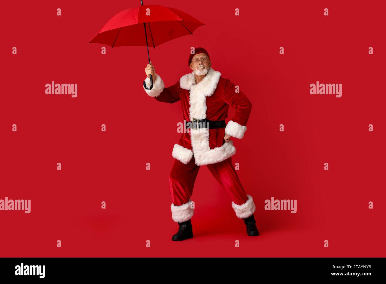 Santa Claus in glasses with umbrella on red background Stock Photo - Alamy