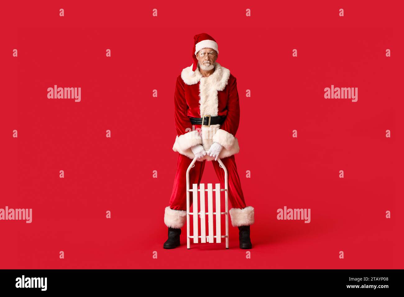 Santa Claus in glasses with sledge on red background Stock Photo - Alamy