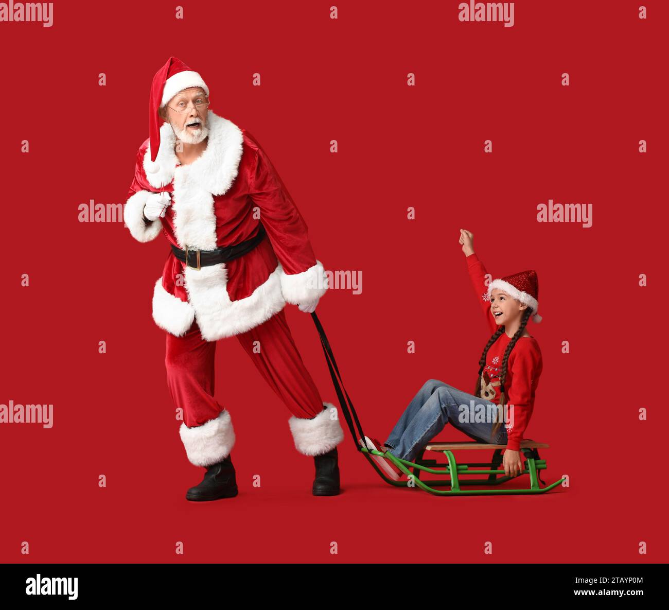 Santa Claus and cute little girl on sledge against red background Stock ...