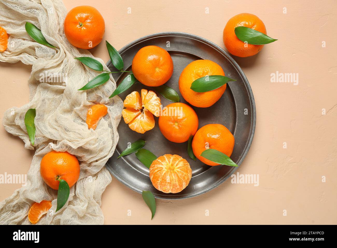 Plate with sweet mandarins and leaves on beige background Stock Photo ...
