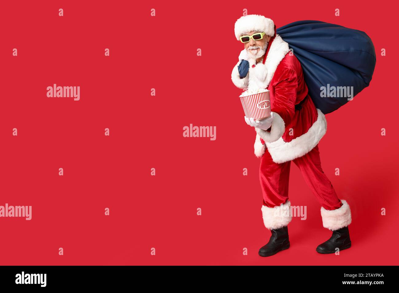 Santa Claus in 3D glasses with bucket of tasty popcorn and bag of gifts ...