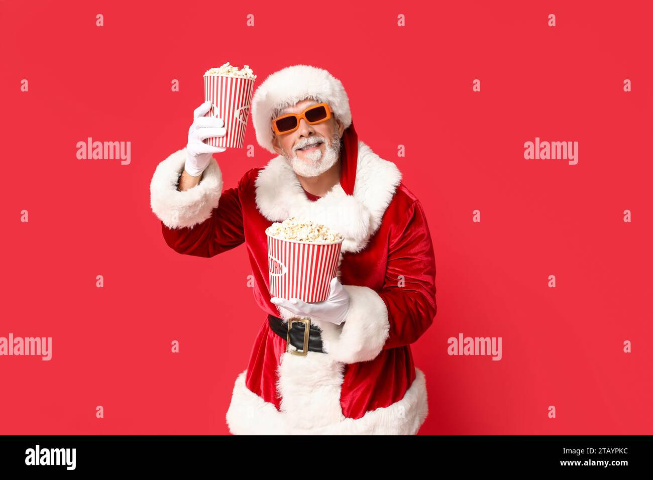Santa Claus in 3D glasses with buckets of tasty popcorn on red ...