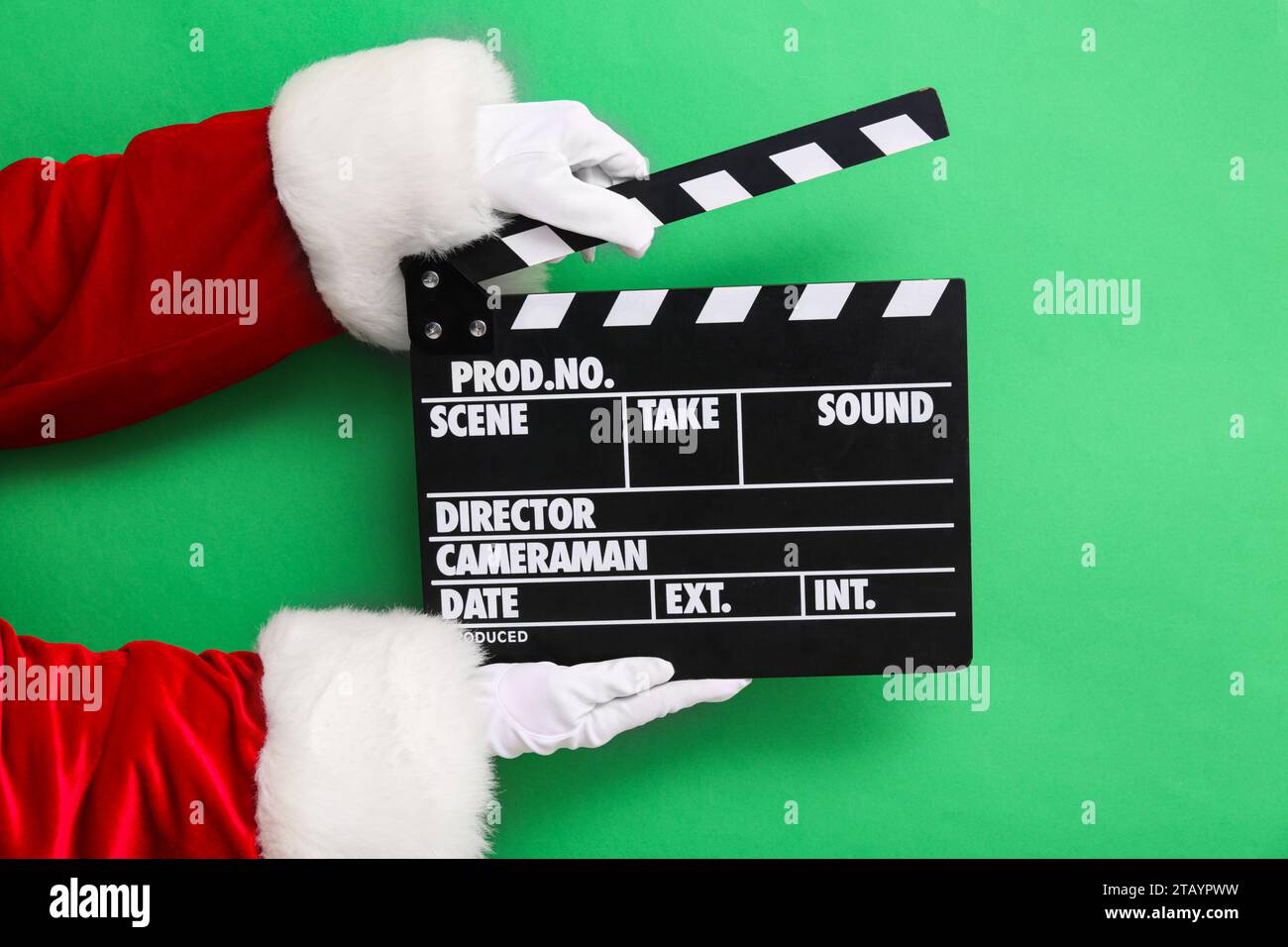 Santa hands with movie clipper on green background Stock Photo - Alamy