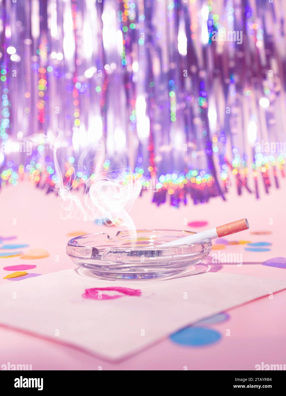 Lit Cigarette with Smoke Amid an Iridescent Tinsel background Party ...