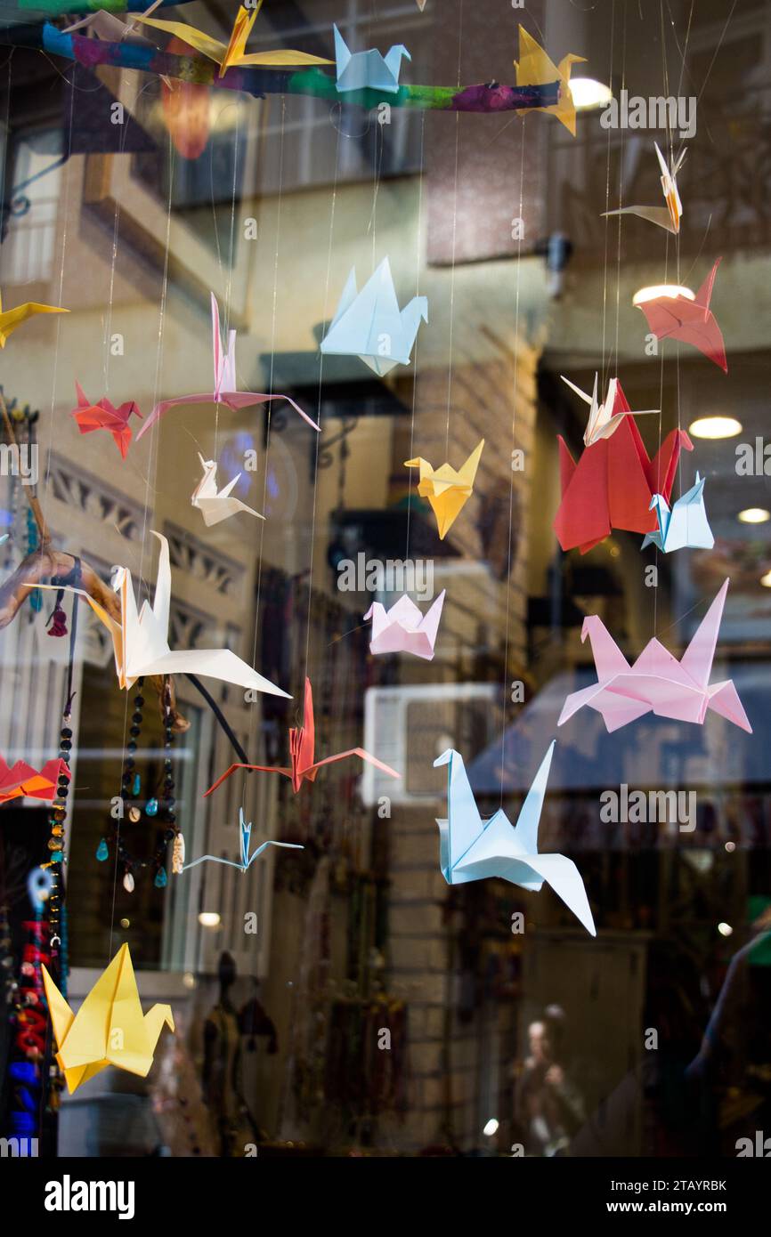 Colorful paper origami birds tied to strings hanging in air Stock Photo ...