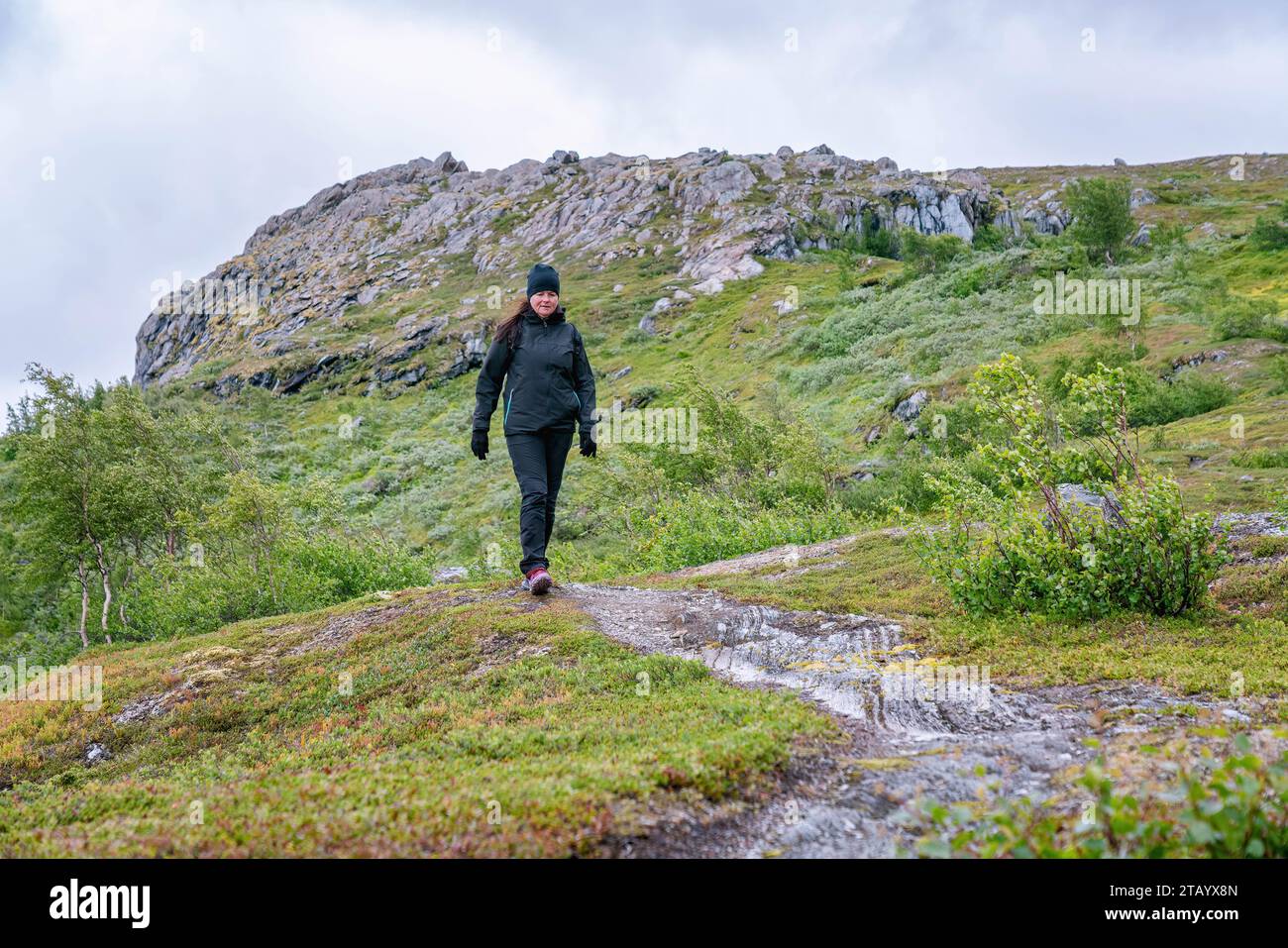 Mature woman walks down in high altitude Norwegian Mountains range ...