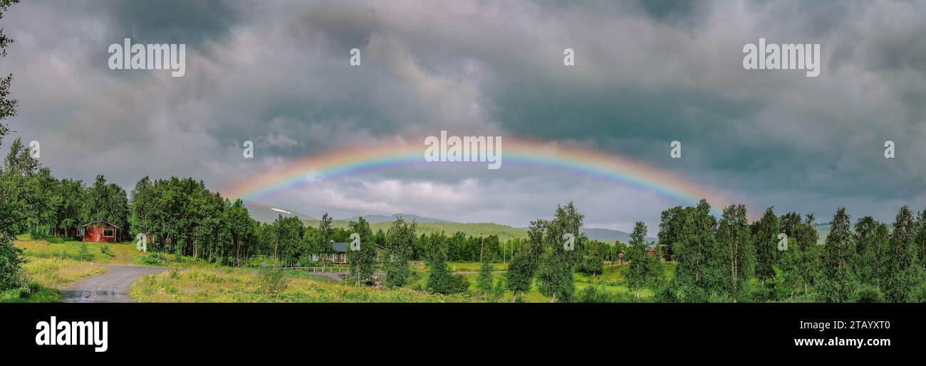 Scenic wide summer rainbow panorama over small mountain village in ...