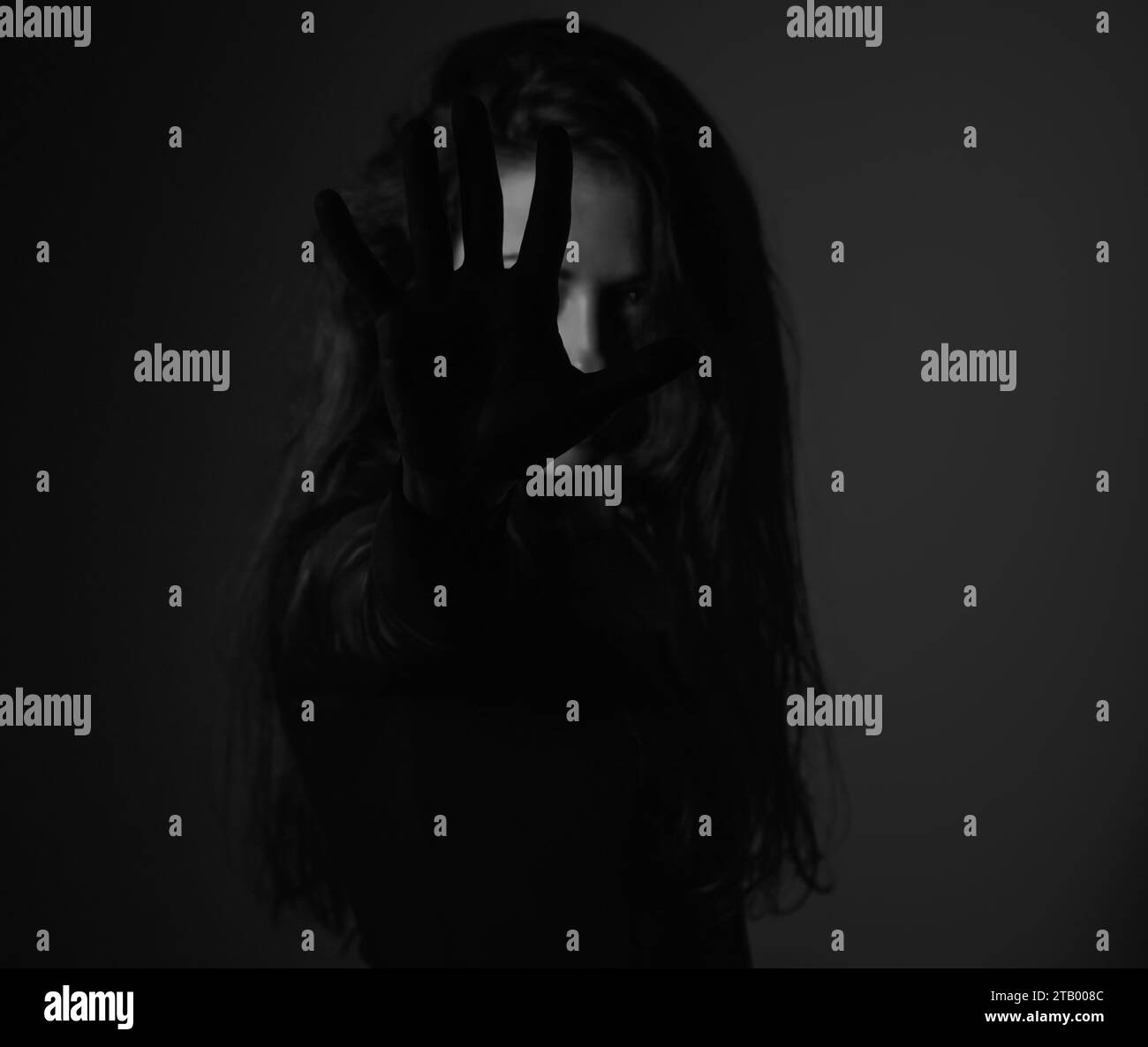 Beauty young woman holding the palm in front of the face signaling the ...