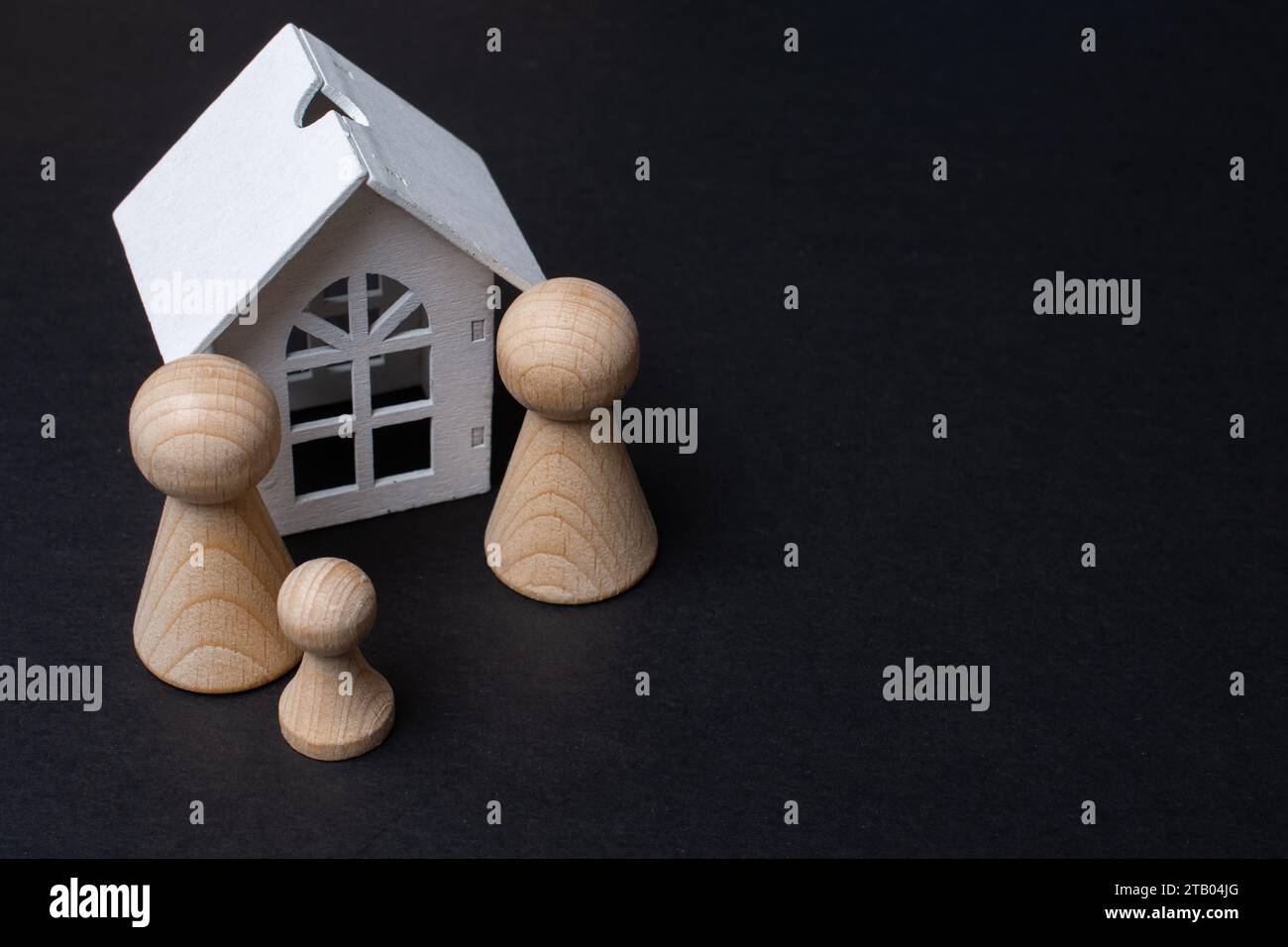 Wooden figurines of people and a model house. concept of family values ...