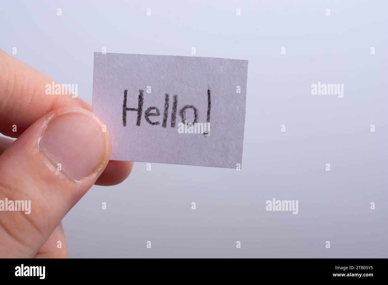 Hand holding notepaper with HELLO wording on white background Stock ...