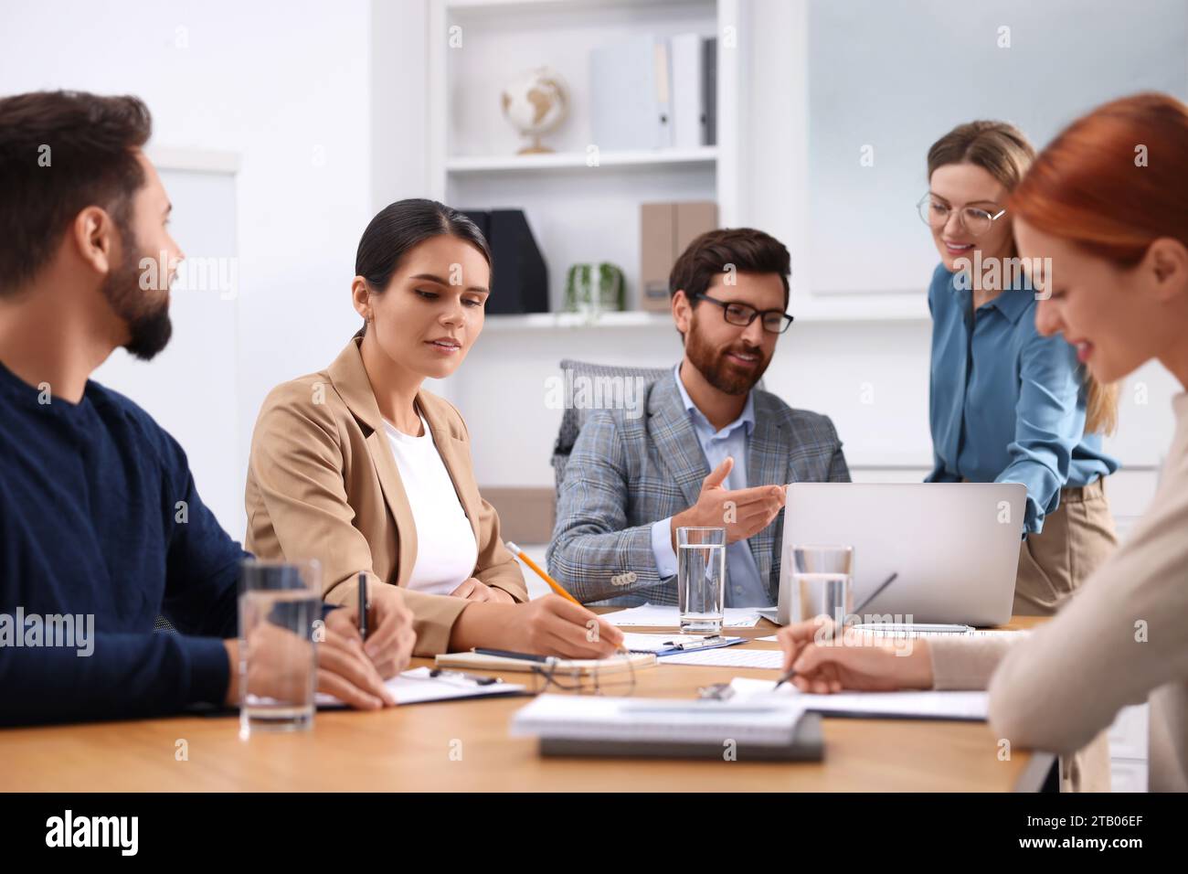 Team of employees working together in office Stock Photo - Alamy