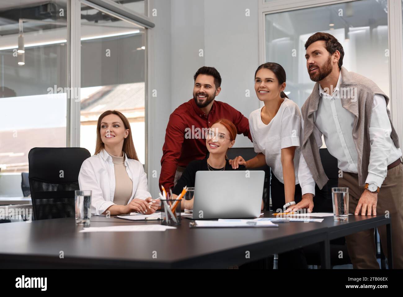 Team of employees working together in office Stock Photo - Alamy