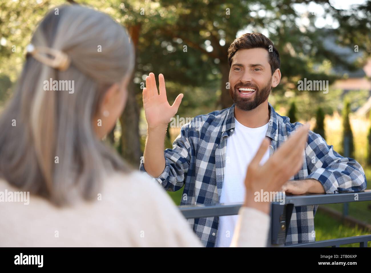 Friendly relationship with neighbours. Happy man greeting senior woman ...