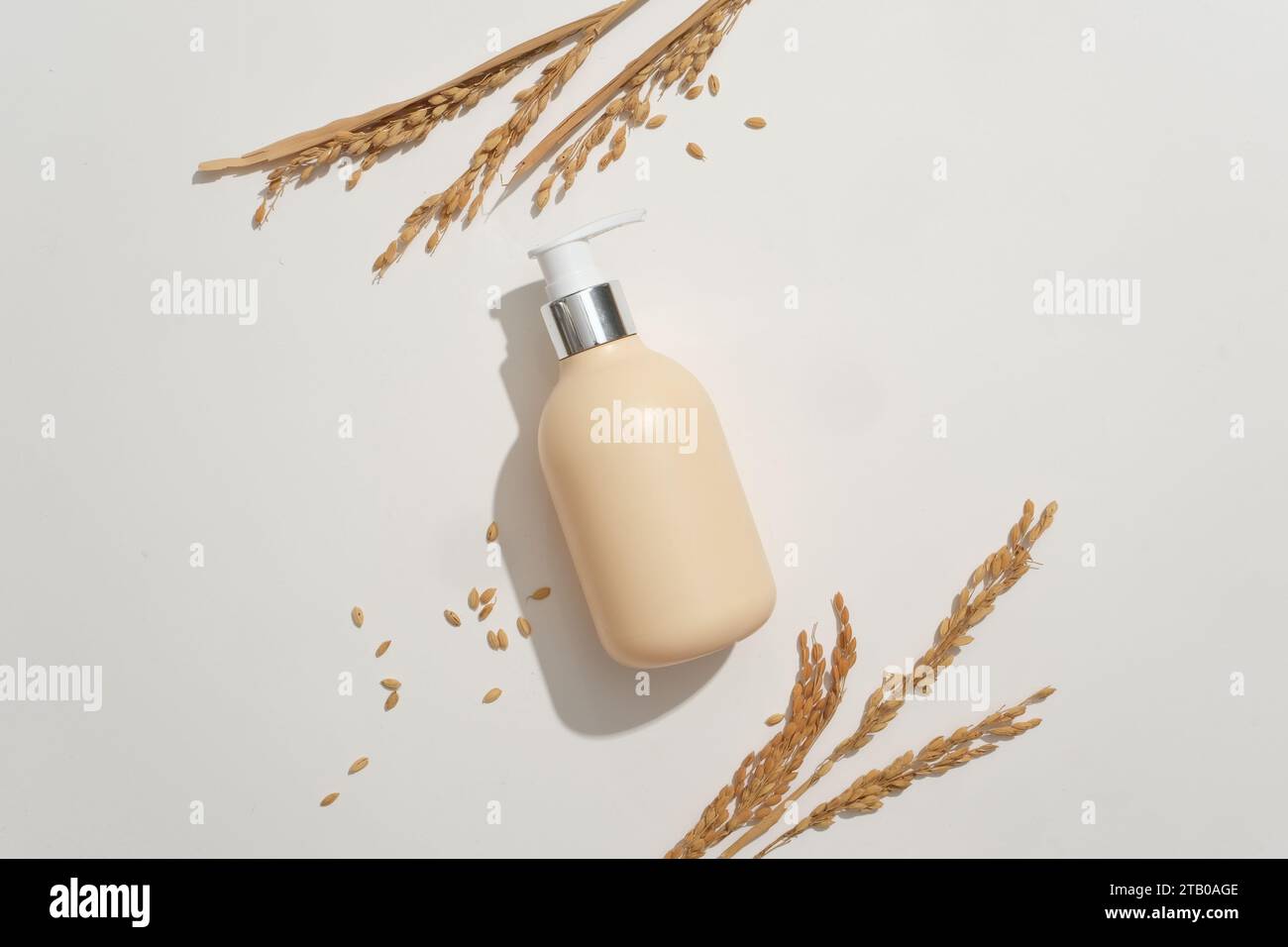 On a white background there is an unbranded cosmetic bottle and rice ...