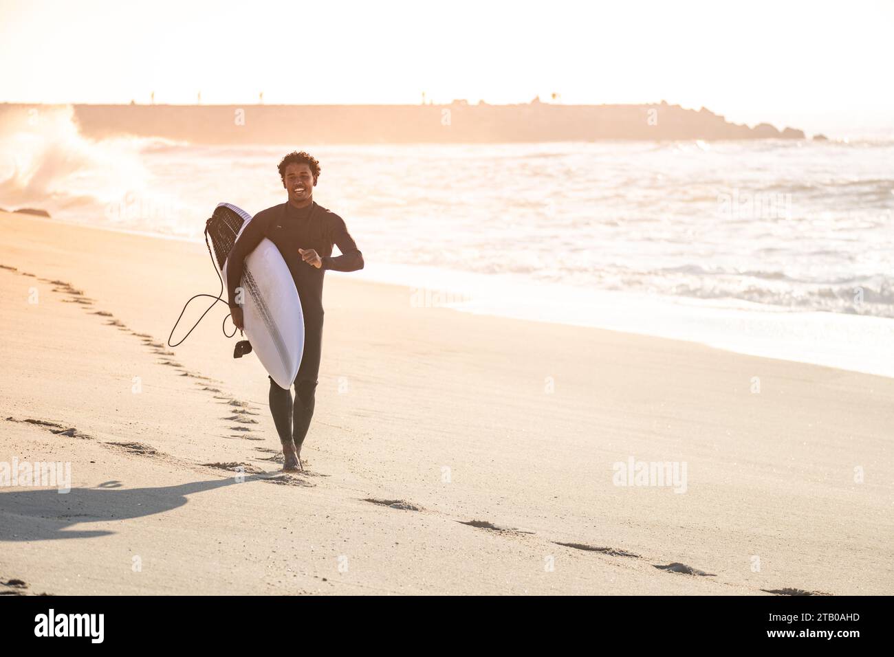 Man surfer run in the beach near the ocean with surfboard Stock Photo ...