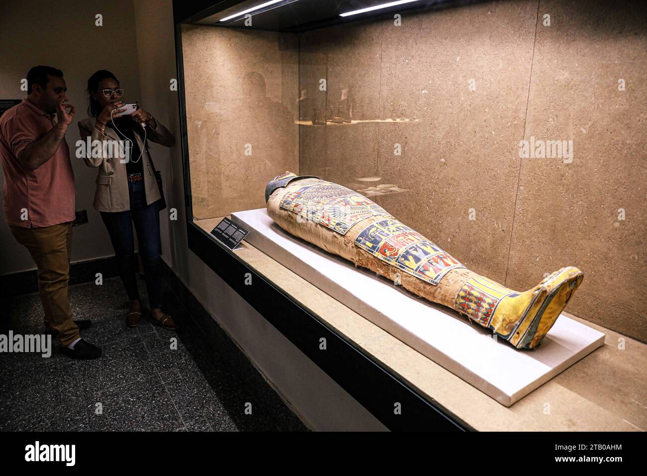 Cairo, Egypt. 3rd Dec, 2023. People look at a mummy on display at the ...