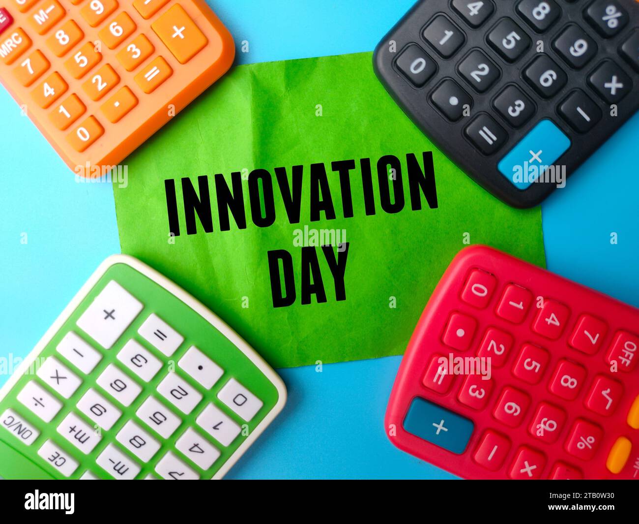 Calculator and colored notepaper with text INNOVATION DAY on a blue ...