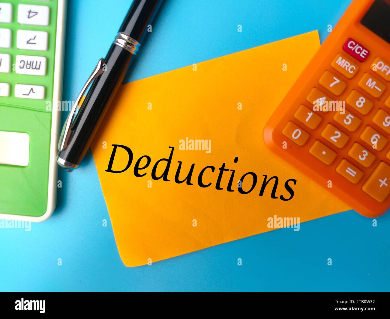 Pen,calculator and colored notepaper with text Deductions on a blue ...