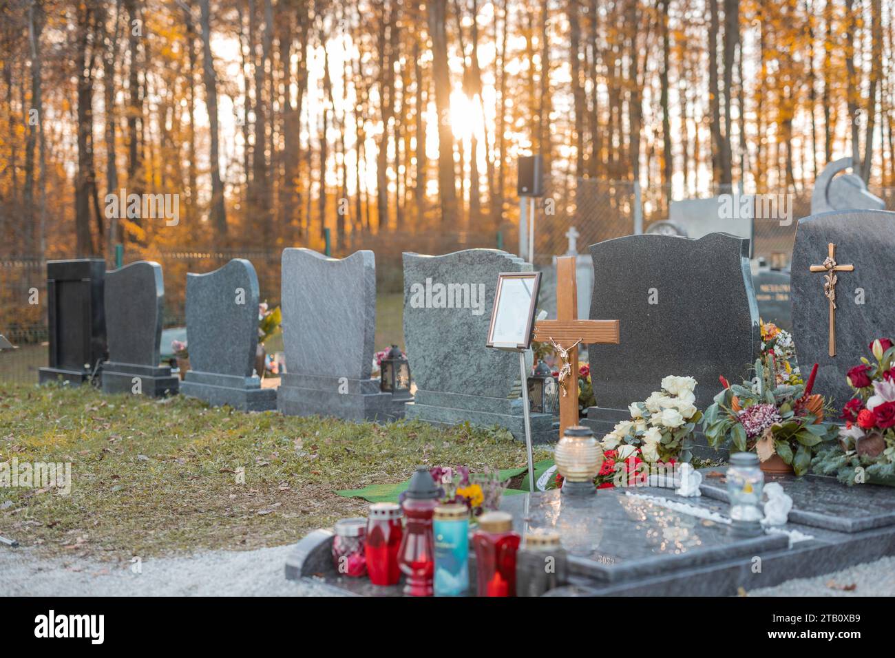 Fresh grave of recently deceased person. Visible memorial stand for the picture and a brown ...