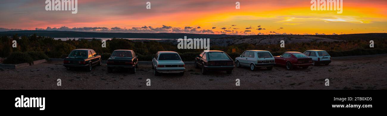 Epic sunset at the seaside and different vintage oldtimer cars viewed ...