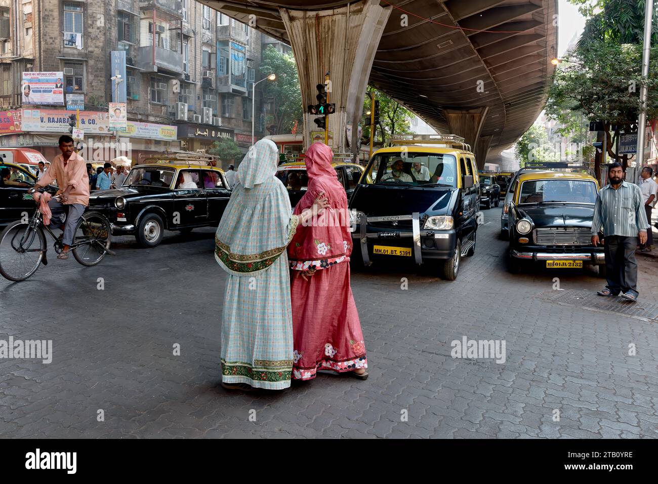 Two Bohra Muslim women in their traditional colorful dress trying to ...