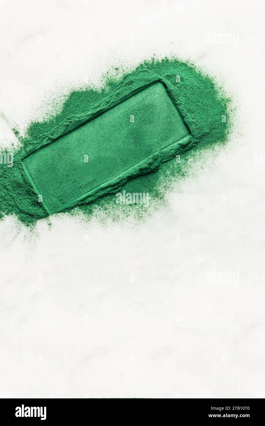 Scattered natural spirulina green algae powder on white background with ...