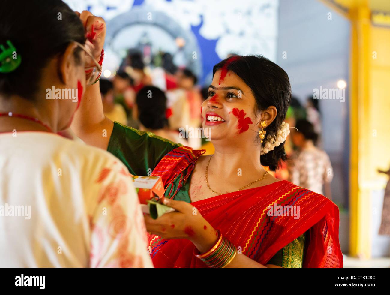 A beautiful woman in traditional dress with red colored smiling face ...