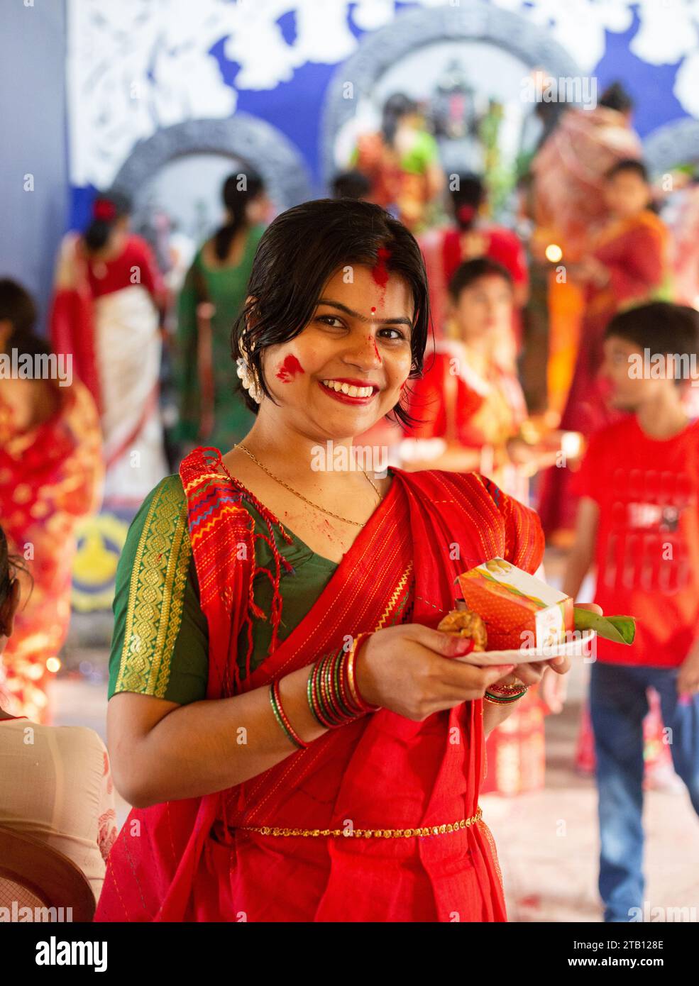A beautiful woman in traditional dress with red colored smiling face ...