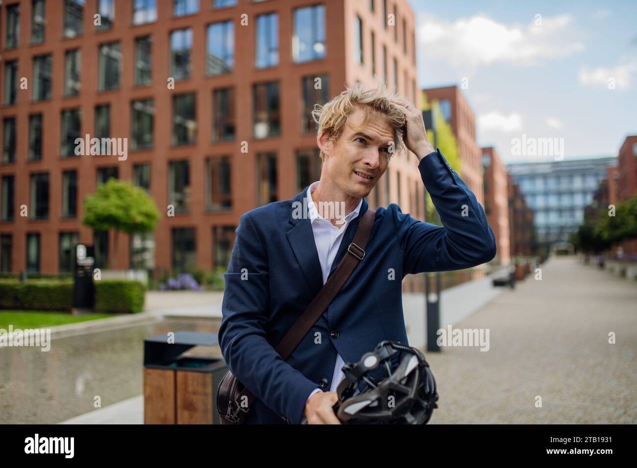 Handsome middle-aged man commuting through the city by bike in suit ...