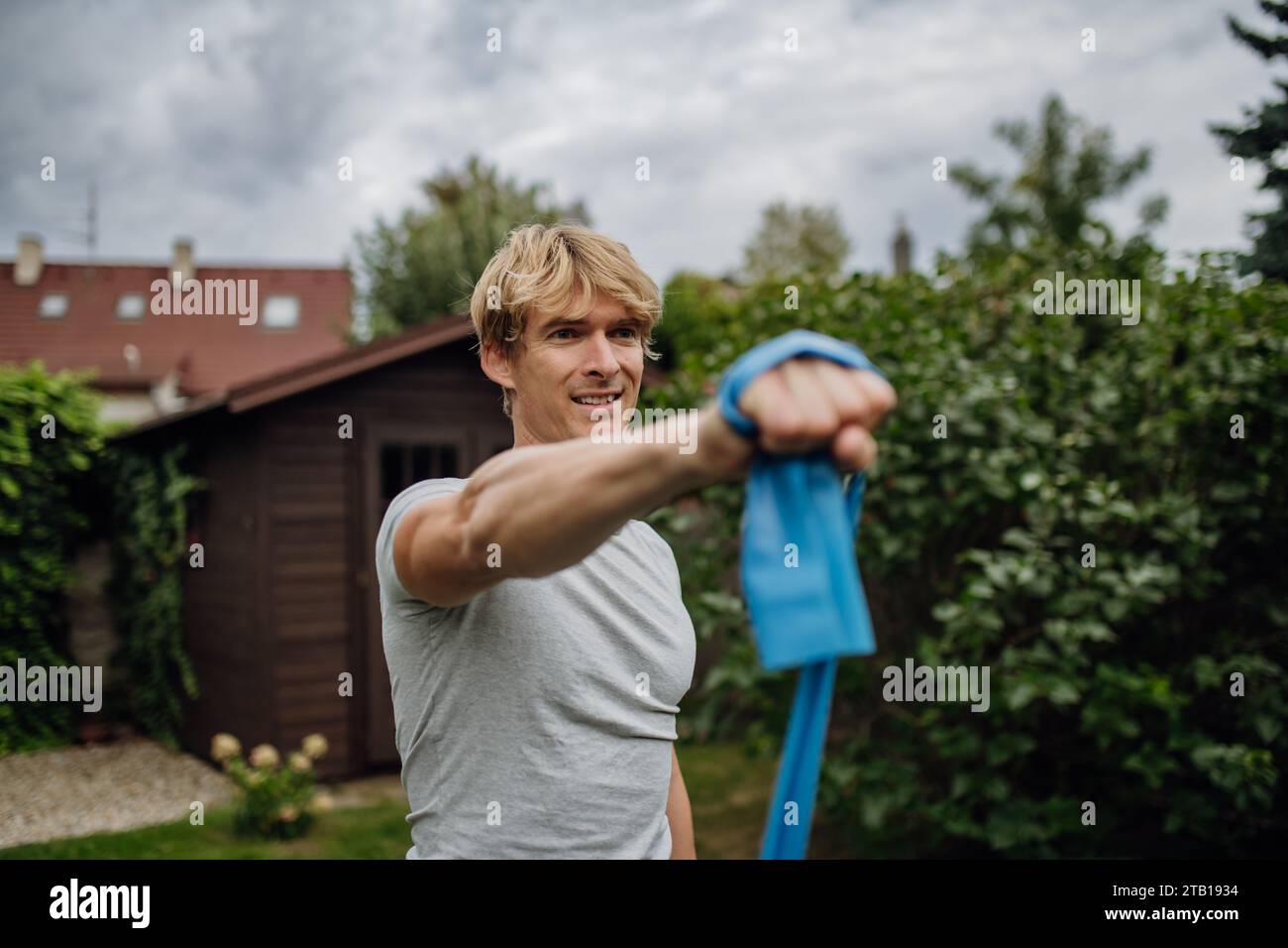 Middle aged man doing strength exercises with resistance band outdoors ...