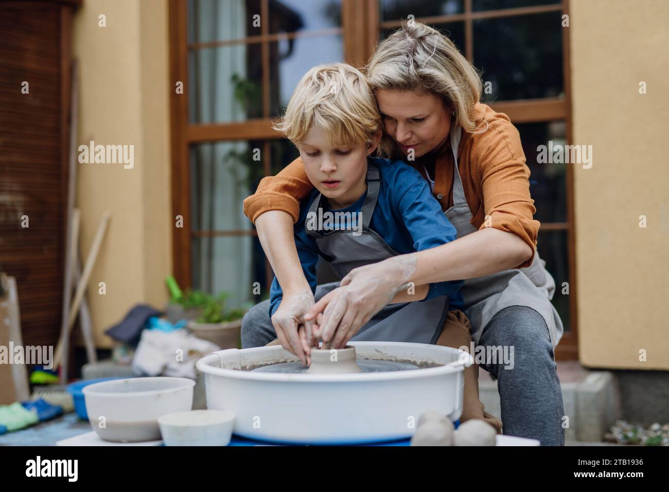 Mother teaching son how make pottery on pottery wheel. Child creative ...