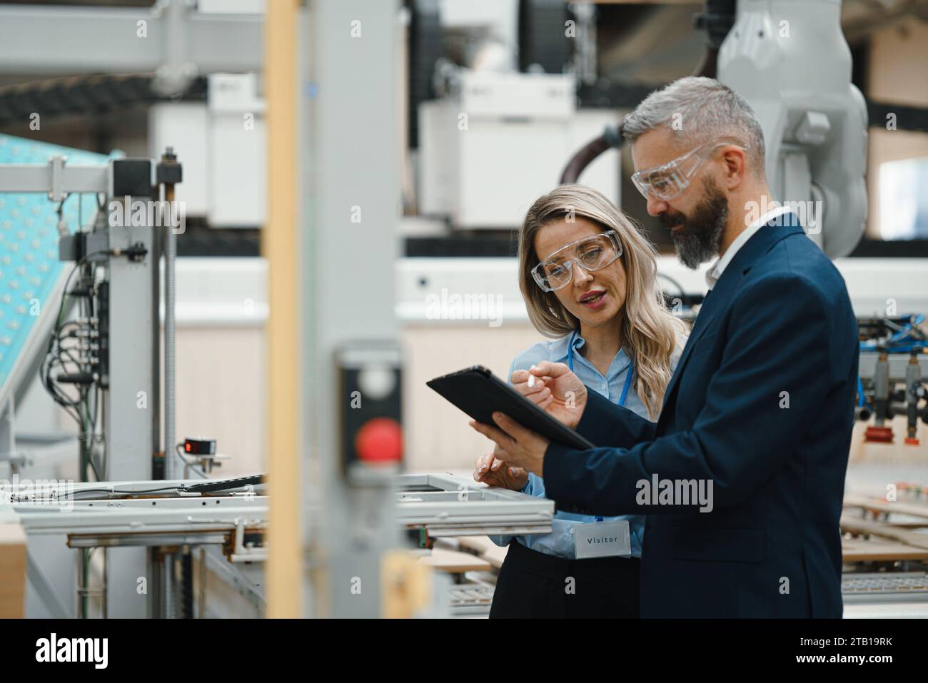 Female engineer and male production manager standing in modern ...