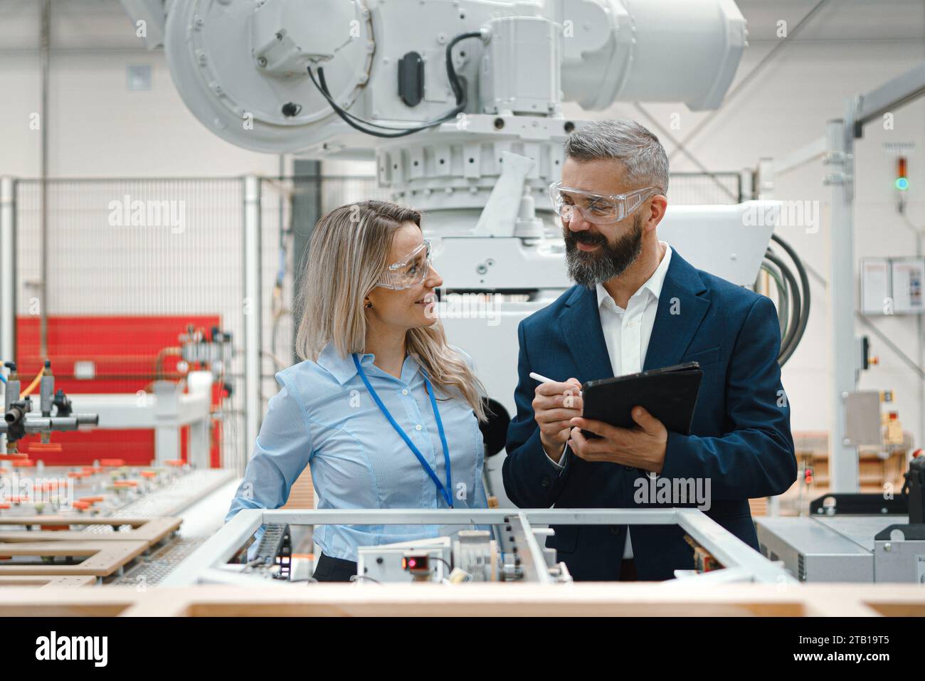 Female engineer and male production manager standing in modern ...