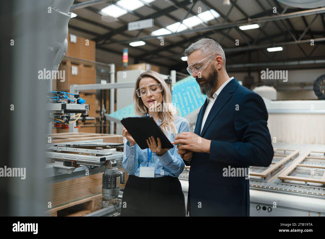 Female engineer and male project manager standing in modern industrial ...