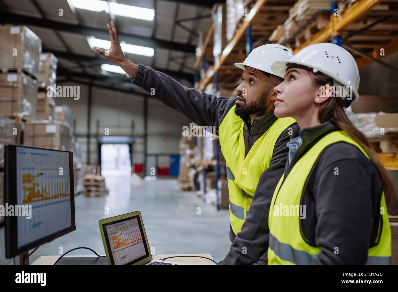 Warehouse manager talking with logistics employee in warehouse ...