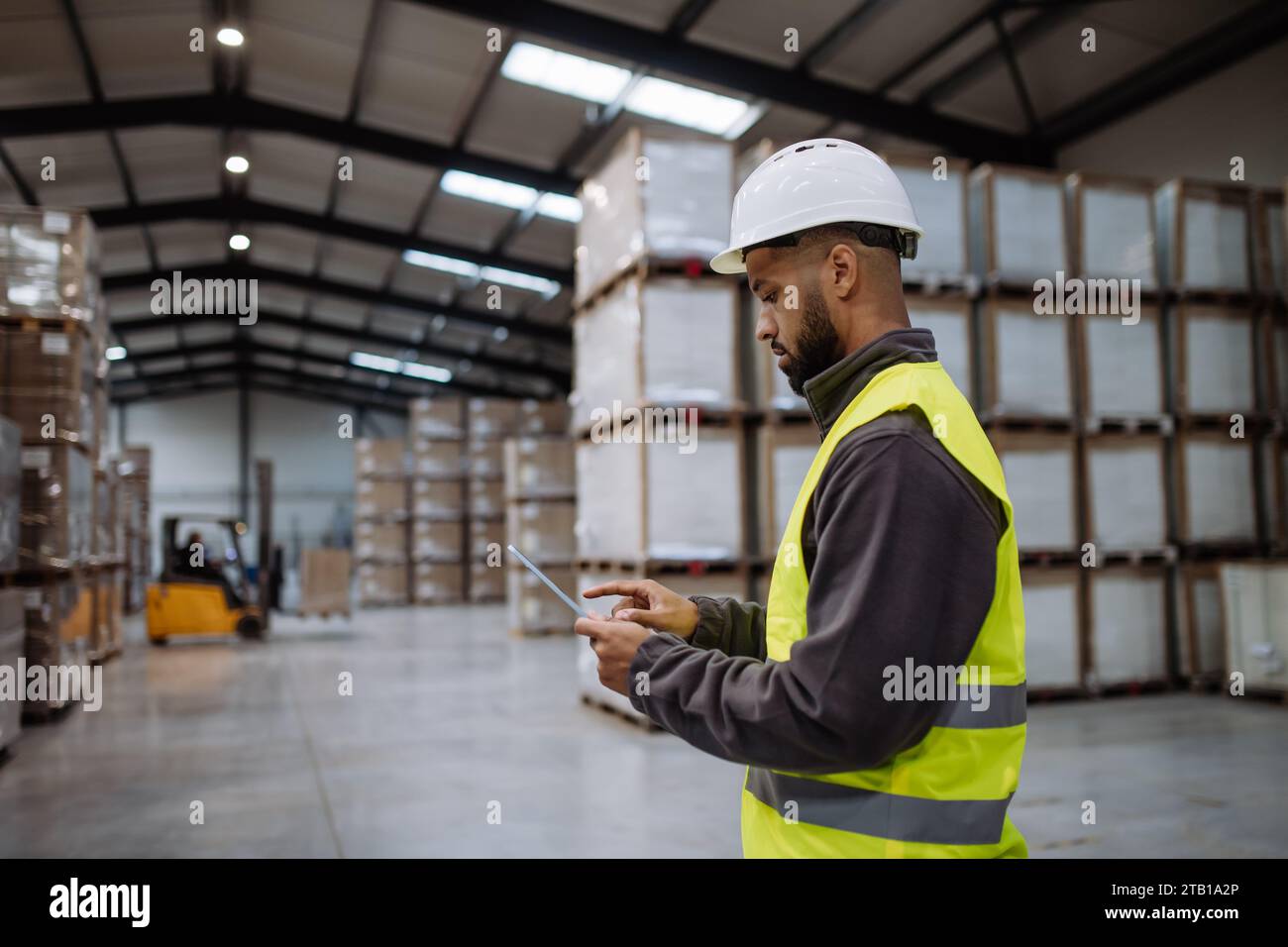 Warehouseman with tablet checking delivery, stock in warehouse ...