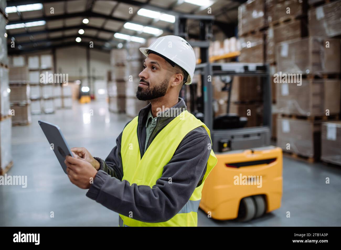 Warehouseman with tablet checking delivery, stock in warehouse ...