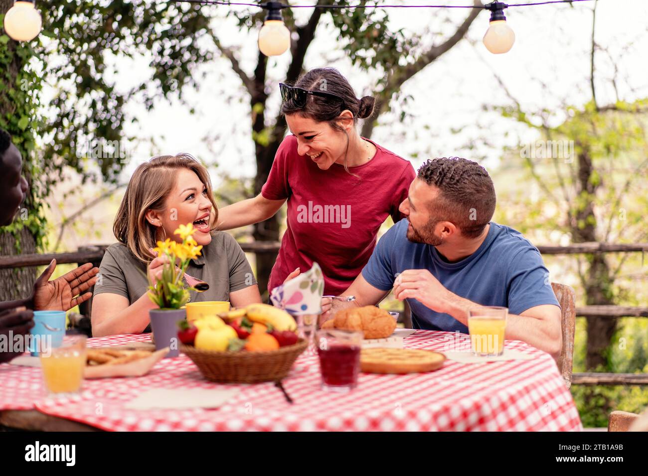 Group of diverse friends laughing and enjoying a picnic, sharing a ...