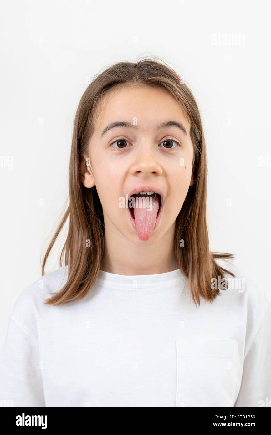 Portrait of a teenage girl showing her tongue isolated on a white ...