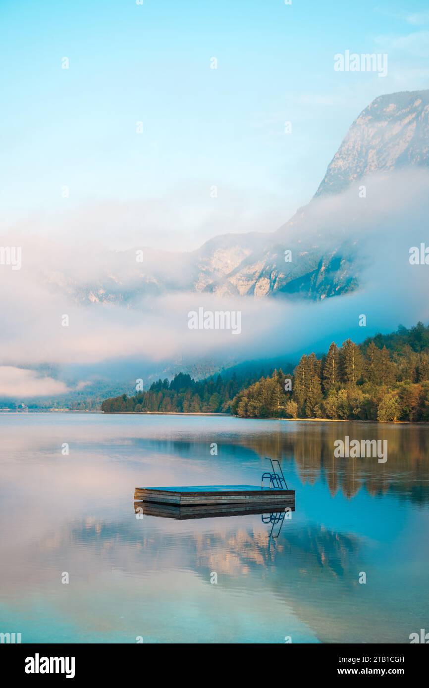 Small floating pier on lake Bohinj surface in summer morning, selective ...