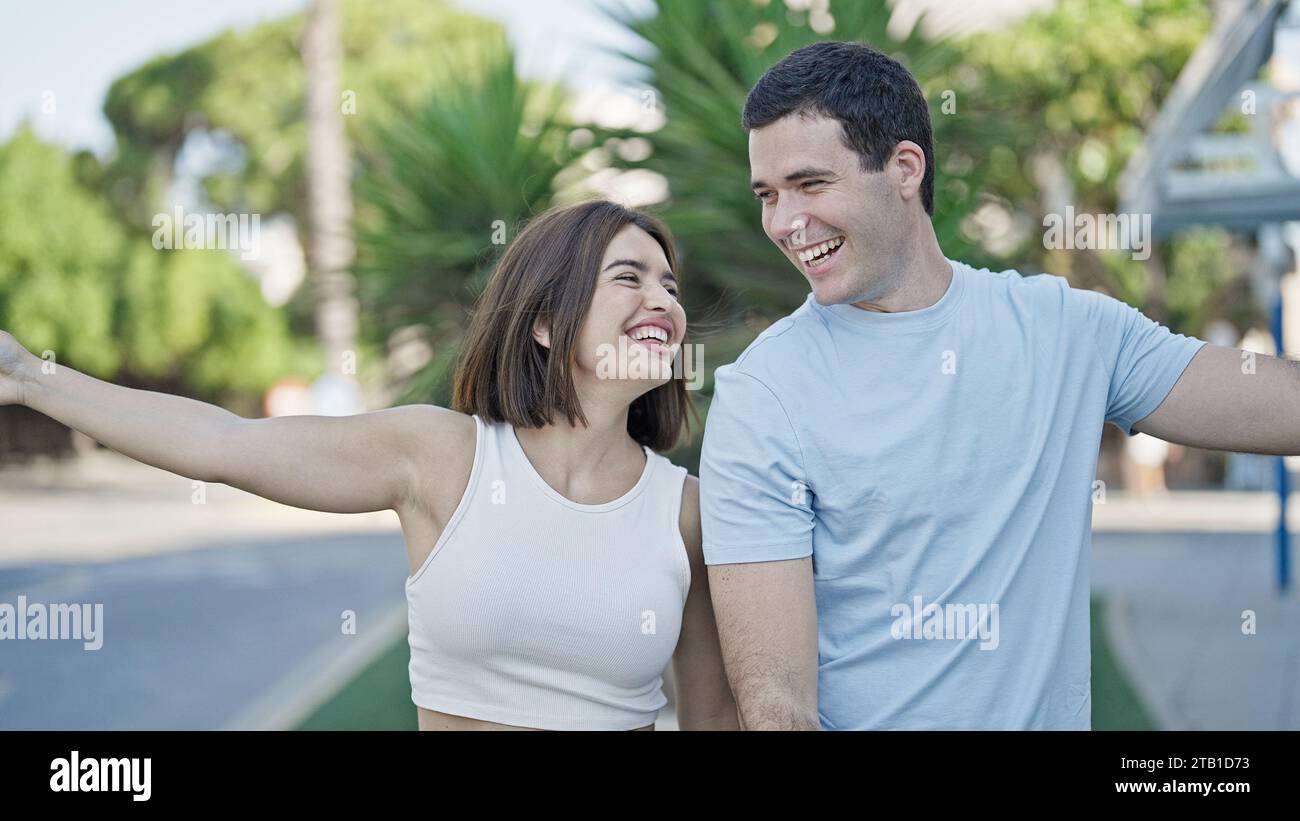Beautiful couple smiling confident standing together dancing at park ...