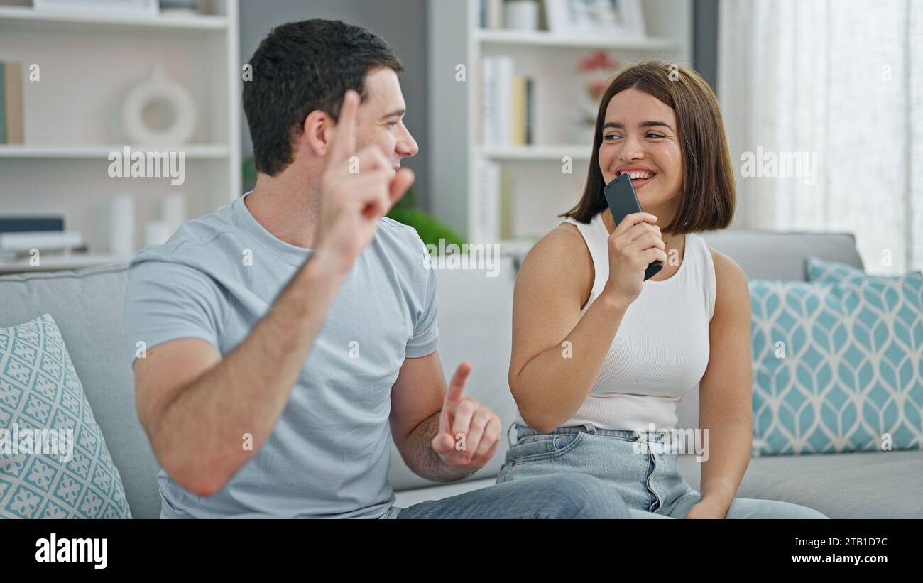 Beautiful couple singing song using tv remote control as a microphone ...
