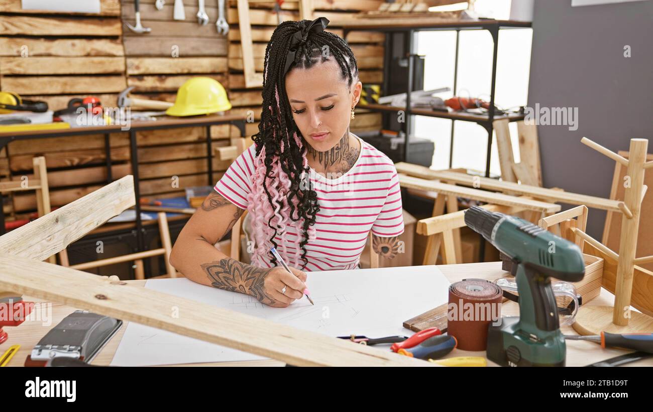Confident hispanic amputee woman, sitting and drawing creative carpentry designs at her ...