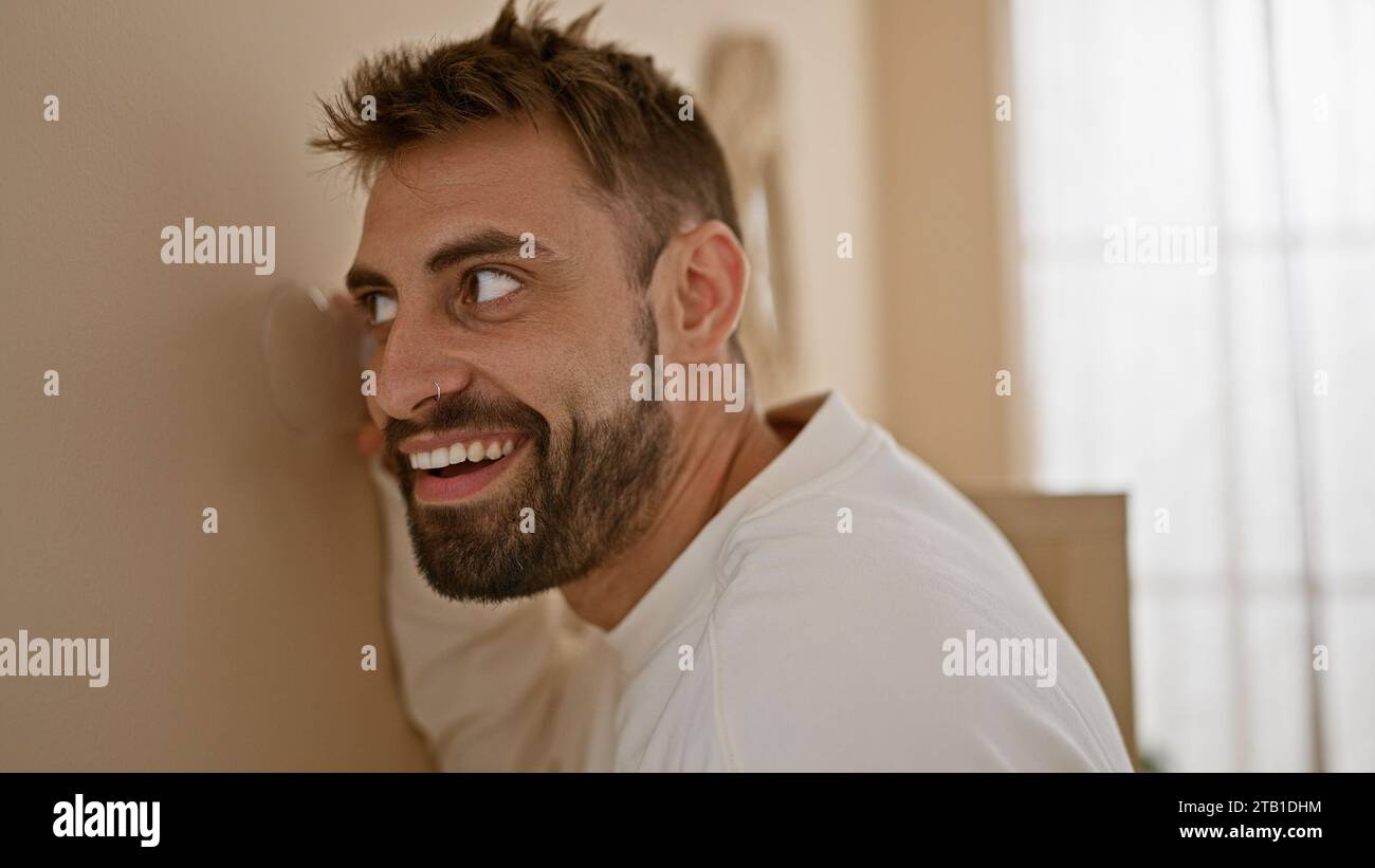 Curiosity sparked! young, smiling hispanic man eavesdropping on juicy ...