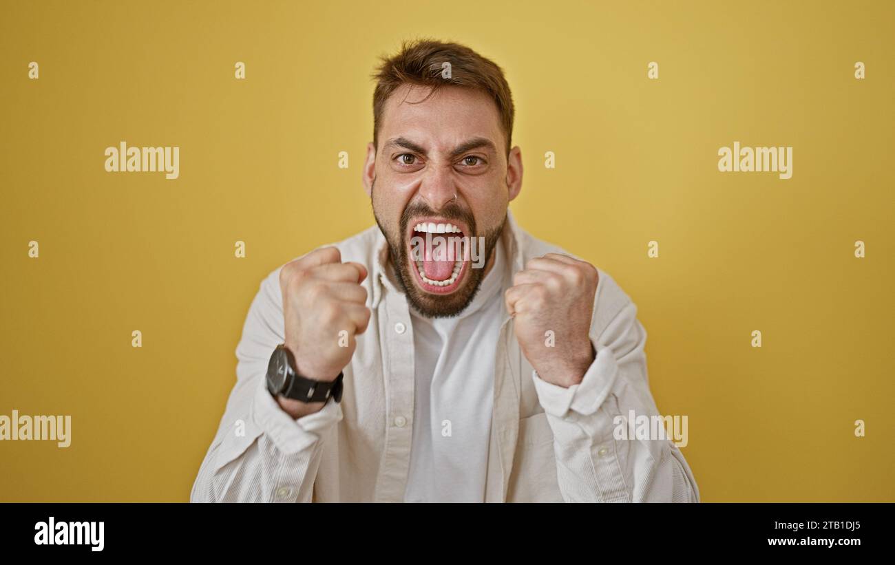 Angry young hispanic man, stressed and screaming, standing against a ...