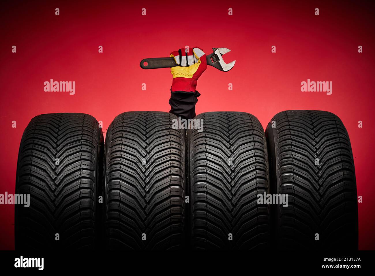 Car tires service and hand with wrench of mechanic man on red ...